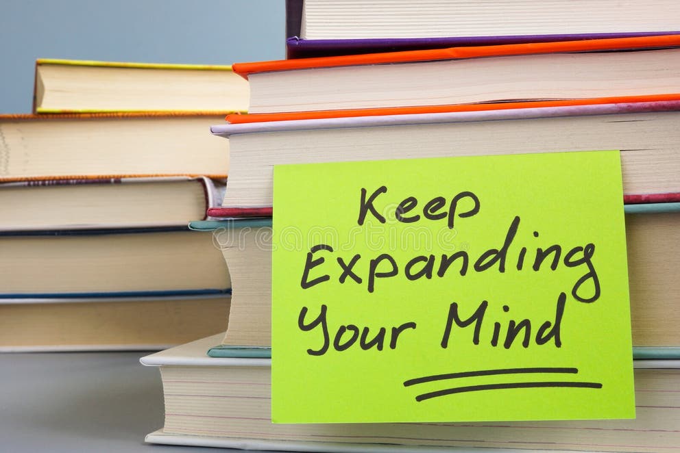 Stack of Books and a Note with the Phrase Keep Expanding Your Mind ...