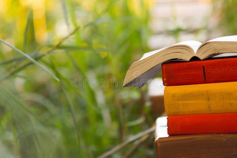 Stack of Books and Open Hardback Book on Blurred Stock Photo - Image of ...