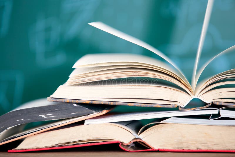 A Stack of Books Opened in Front of the Blackboard Stock Photo - Image ...