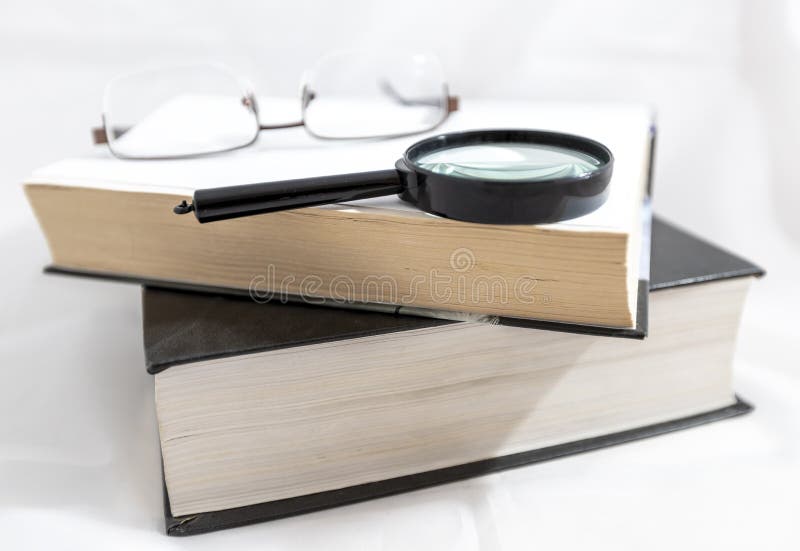 Stack of Books and Spectacles on White Background with Magnifying Lens ...