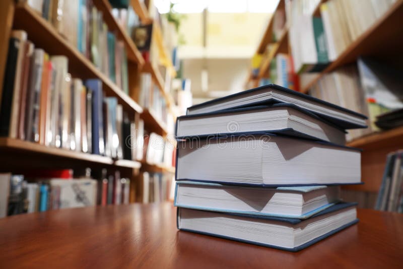 Stack of Books on Table in Library Stock Image - Image of blurred ...