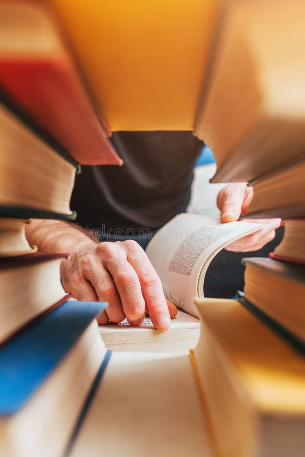 Through a Stack of Books a View of a Reading Man in a Library Stock ...