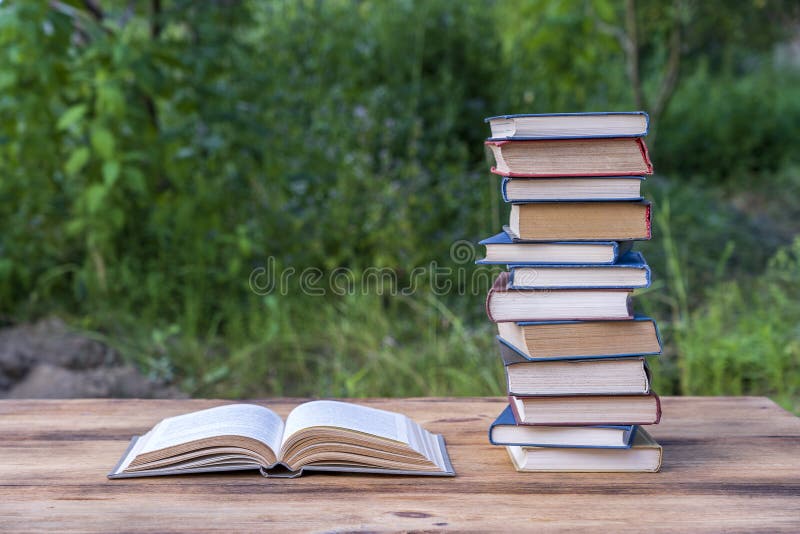 Stack of Books on Wooden Table Over Nature Background, Outdoors Stock ...