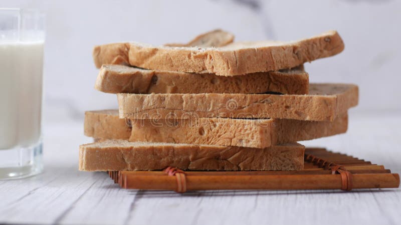 Stack of Bread and Glass of Milk on Table Stock Footage - Video of ...