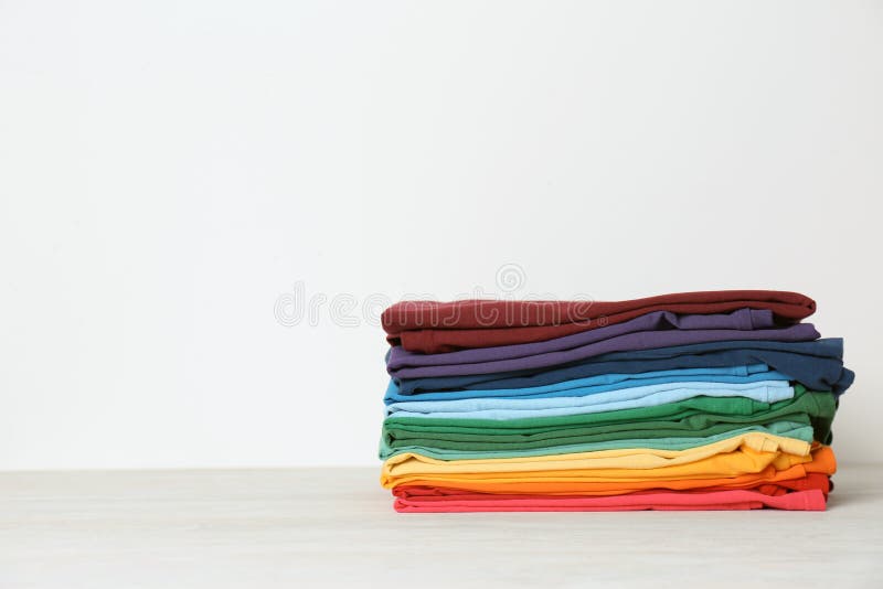 Stack of Bright Folded Clothes on Table Against White Background Stock ...