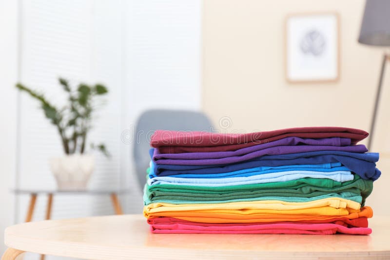 Stack of Bright Folded Clothes on Table Indoors Stock Image - Image of ...
