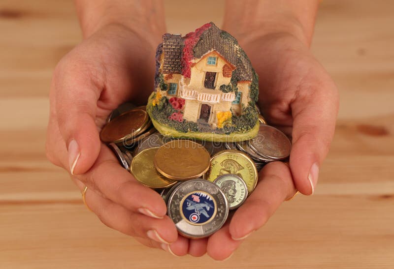 Stack of Canadian Coins in Hand with Miniature House. Editorial Stock ...