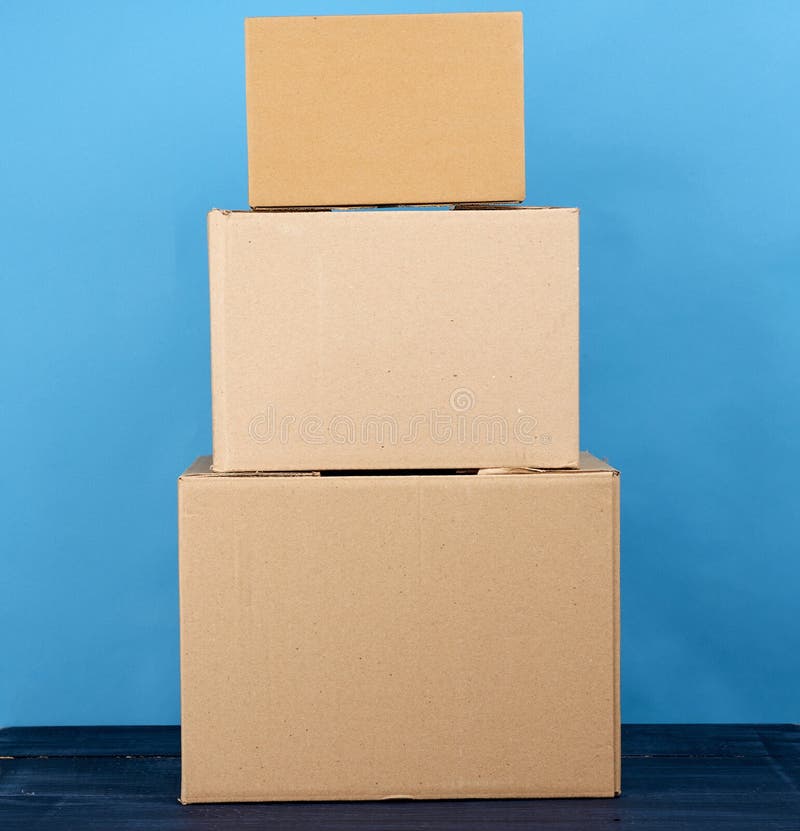 Stack of Cardboard Boxes of Brown Kraft Paper on a Blue Wooden Table ...