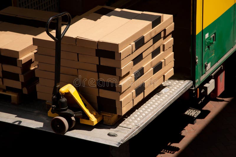 A Stack of Cardboard Boxes on a Pallet is Being Loaded or Unloaded from ...