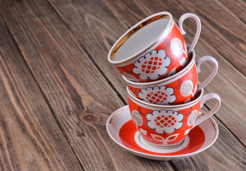 A Stack of Ceramic Retro Cups with Red Patterns on a Wooden Background ...