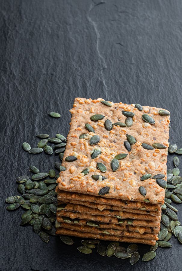 Stack of Cheese and Pumpkin Seed Organic Crispbread on Black Stone ...