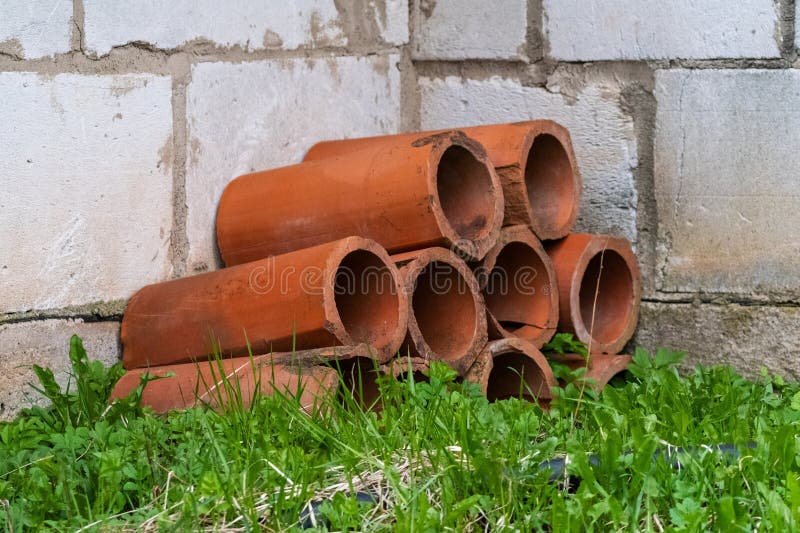Stack of Clay Pipes on Grass in Front of Brick Wall Stock Photo - Image ...