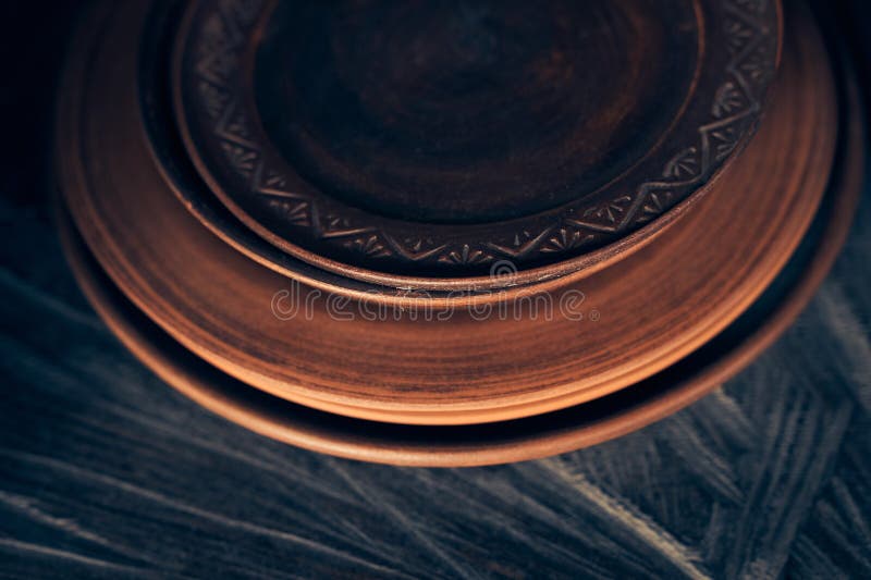 A Stack of Clay Plates of Different Sizes on a Dark Background. Level ...