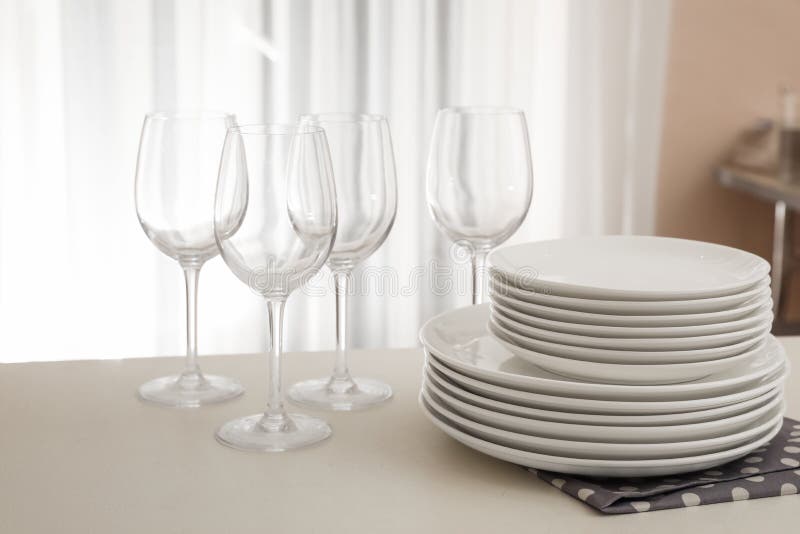 Stack of Clean Dishes and Glasses on Table Stock Photo - Image of ...