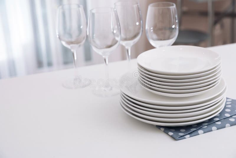 Stack of Clean Dishes and Glasses on Table in Kitchen Stock Photo ...