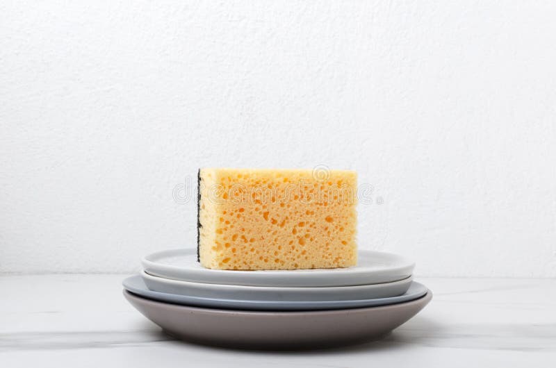 Stack of Clean Dry Plates and Sponge for Cleaning on the Kitchen Table ...