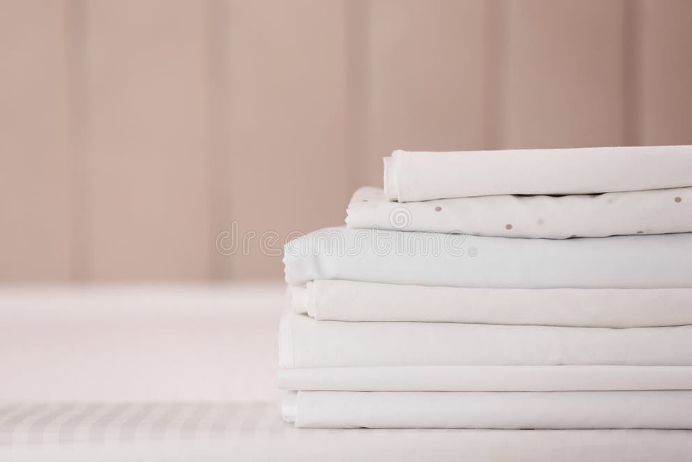 Stack of Clean Folded Linens on Bed Indoors. Space for Text Stock Image ...