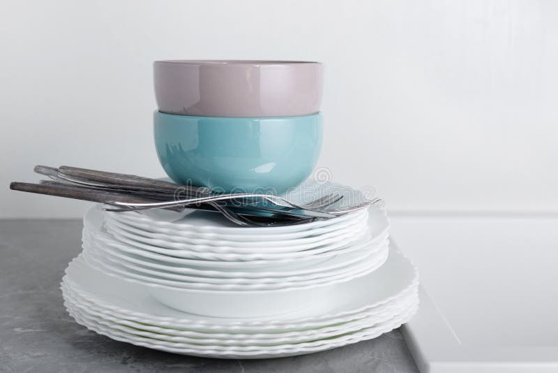 Stack of Clean Plates with Forks, Knives and Glasses for Serving on ...