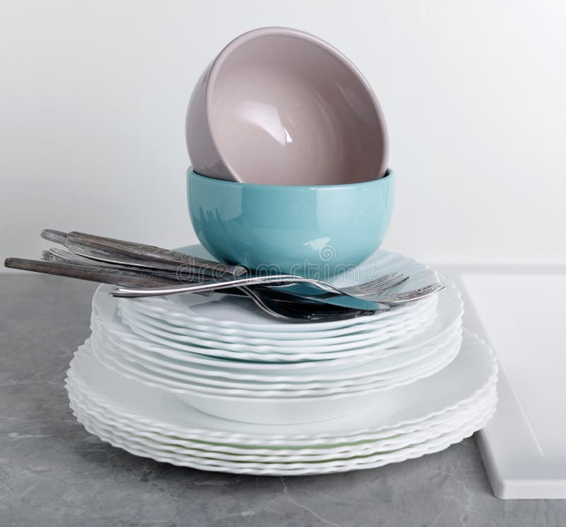 Stack of Clean Plates with Forks, Knives and Glasses for Serving on ...