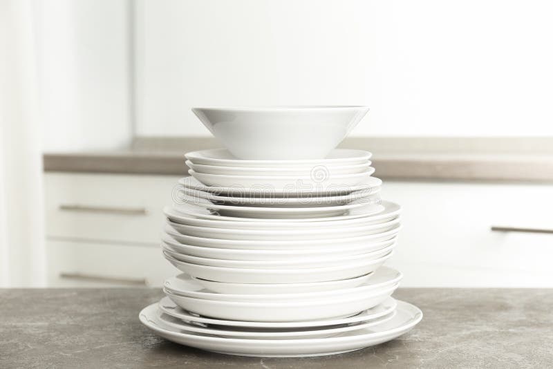 Stack of Clean Plates on Table in Kitchen Stock Photo - Image of group ...