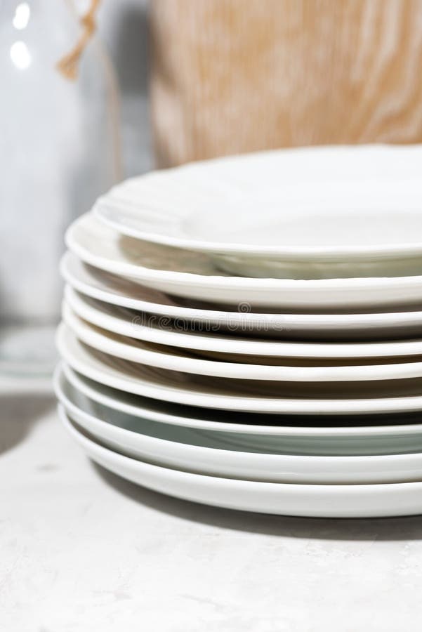 Stack of Clean Plates on White Table, Vertical Stock Image - Image of ...