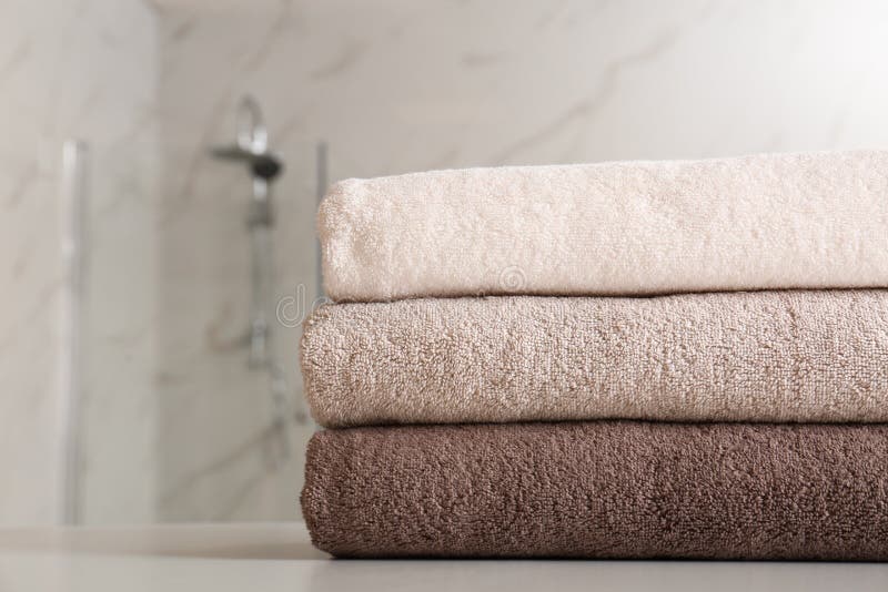 Stack of Clean Towels on Table in Bathroom, Closeup. Stock Image ...
