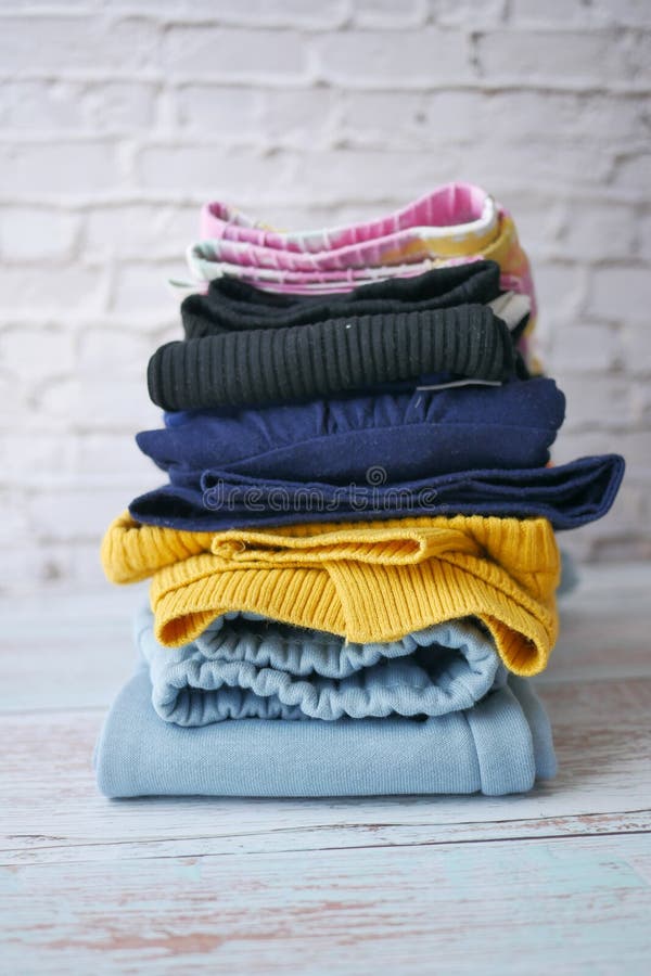 Stack of Clothes on Table Indoor. Stock Image - Image of wear ...