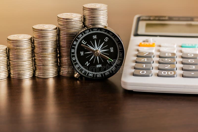 Stack of Coins with Calculator and Compass on Wood Table Stock Photo ...