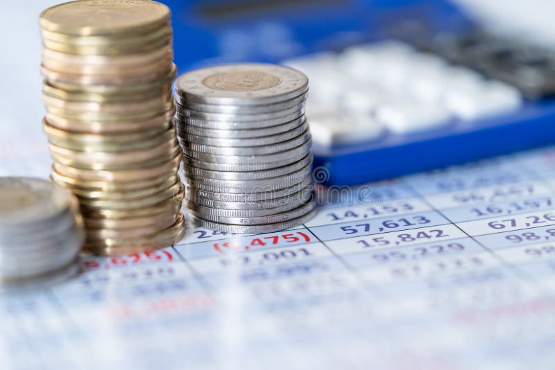 Stack of Coins with Calculator and Financial Report Spreadsheet ...