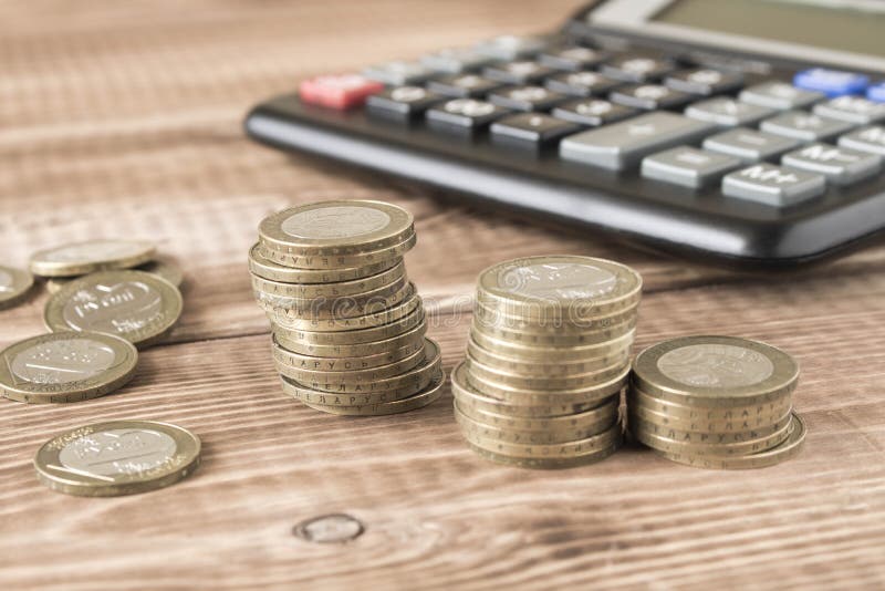 A Stack of Coins and a Calculator on a Wooden Table. Concept of Savings ...