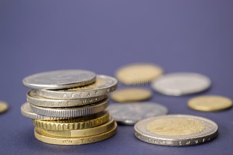Stack of Coins from Different Countries on a Purple Background Stock ...