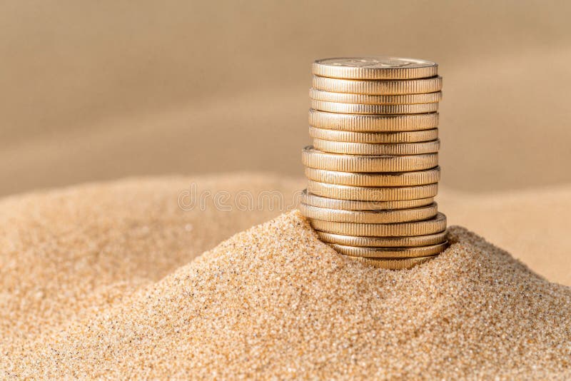 Stack of Coins Emerging from a Sandy Surface Representing Wealth and ...