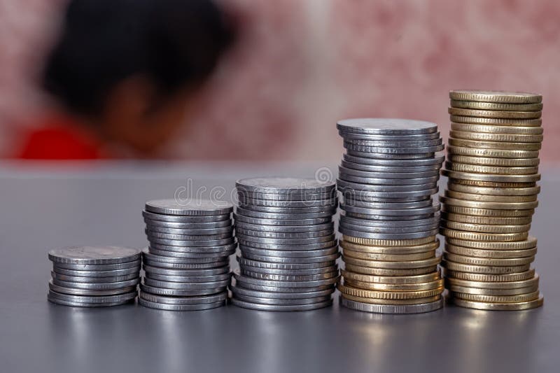 Stack of Coins with Blurred Kids Sitting in Background Stock Image ...