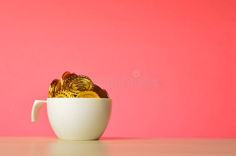 Stack of Coins in a Mug Isolated on a Red Background. Saving Money ...