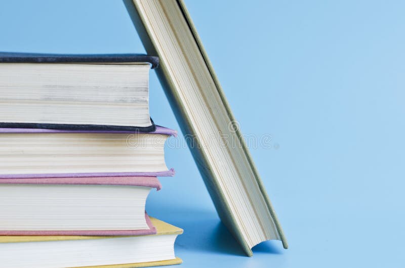 A Stack of Colorful Books on a Blue Background Stock Photo - Image of ...