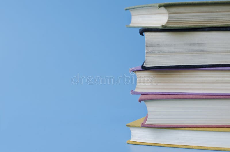 A Stack of Colorful Books on a Blue Background Stock Photo - Image of ...
