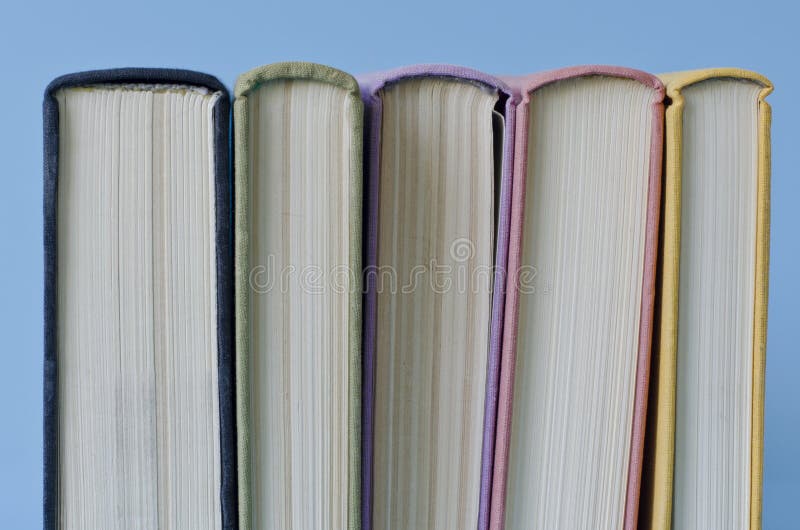 A Stack of Colorful Books on a Blue Background Stock Photo - Image of ...