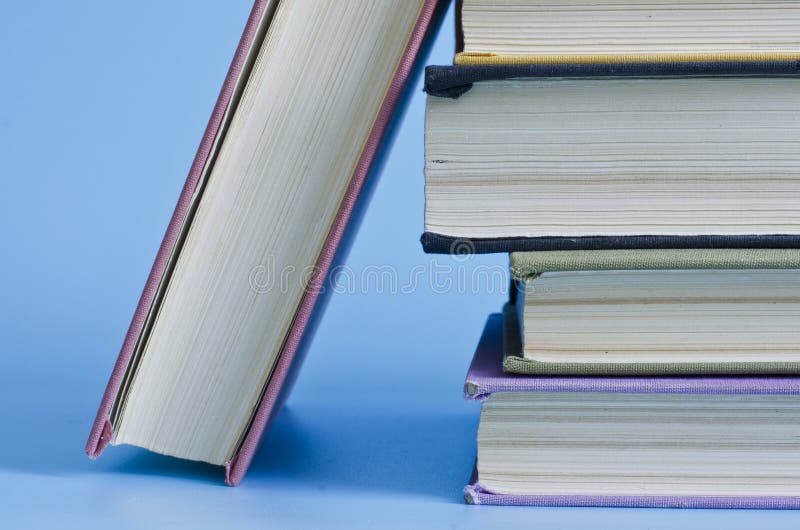A Stack of Colorful Books on a Blue Background Stock Image - Image of ...