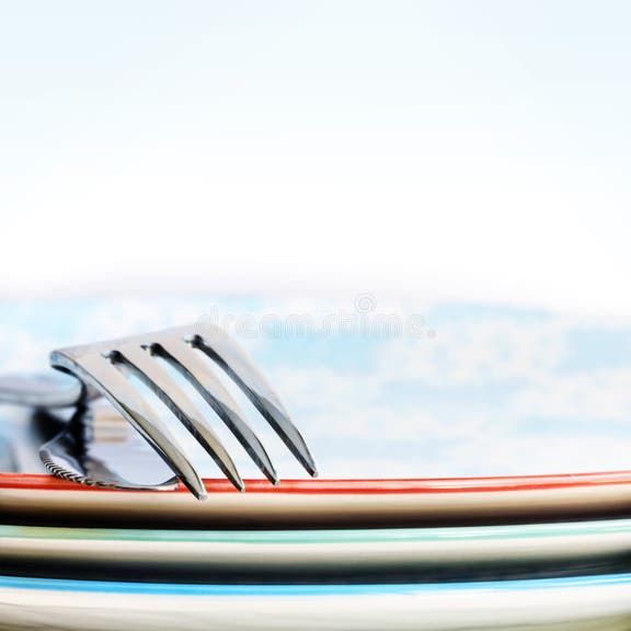 Stack of Colorful Plates Side View with Knife and Fork Stock Photo ...