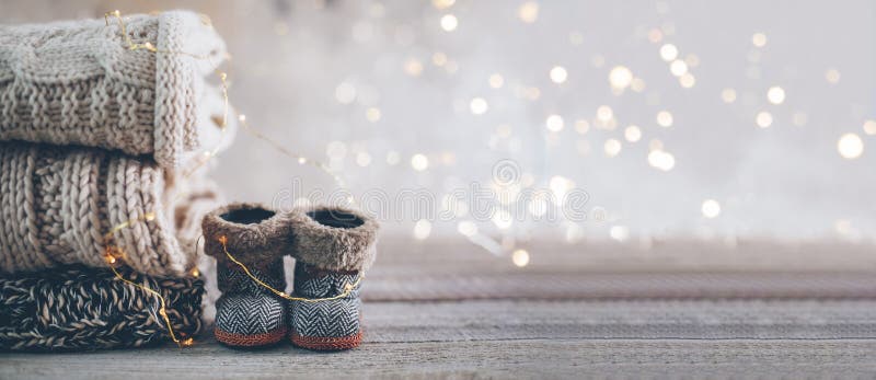 Stack of Cozy Winter Knitted Sweaters and Cute Small Boots on a Blurred ...