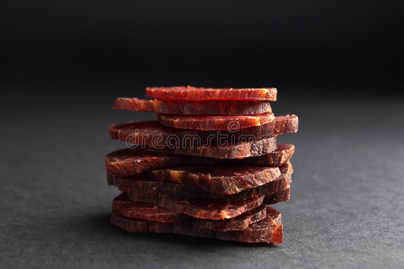 Stack of Delicious Beef Jerky on Dark Table, Closeup Stock Photo ...