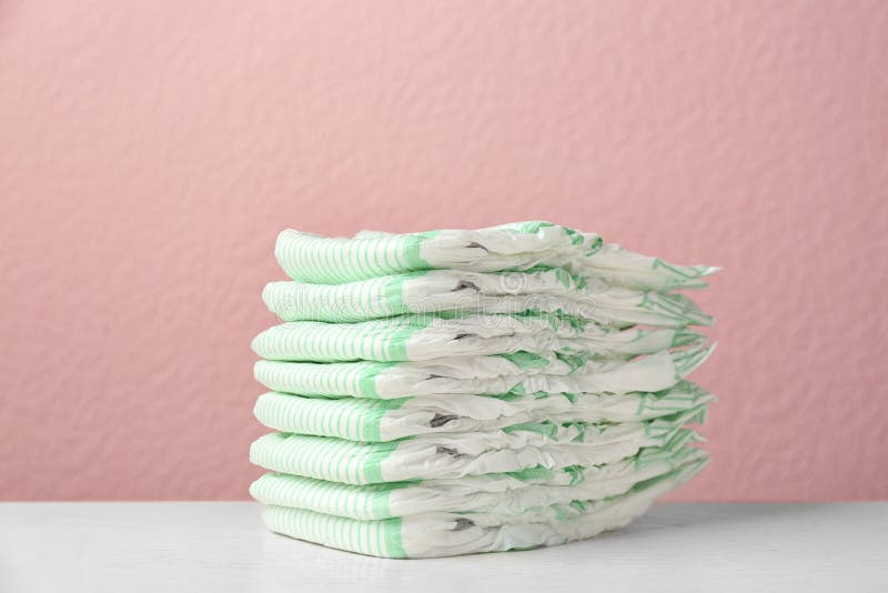Stack of Diapers on Table Against Color Background Stock Photo - Image ...