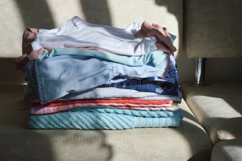 A Stack of Ironed Clothes on the Couch. Household Items. Background for ...