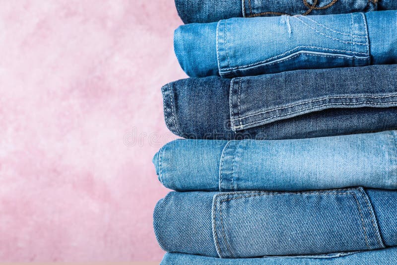 Stack of Different Jeans on Pink, Closeup Stock Photo - Image of ...