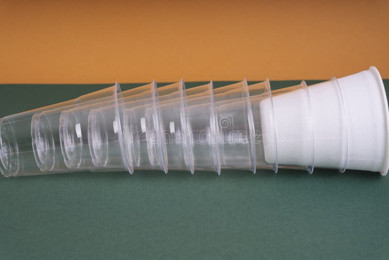 Stack of Disposable Plastic Cups and Paper Over Dark Green Background ...