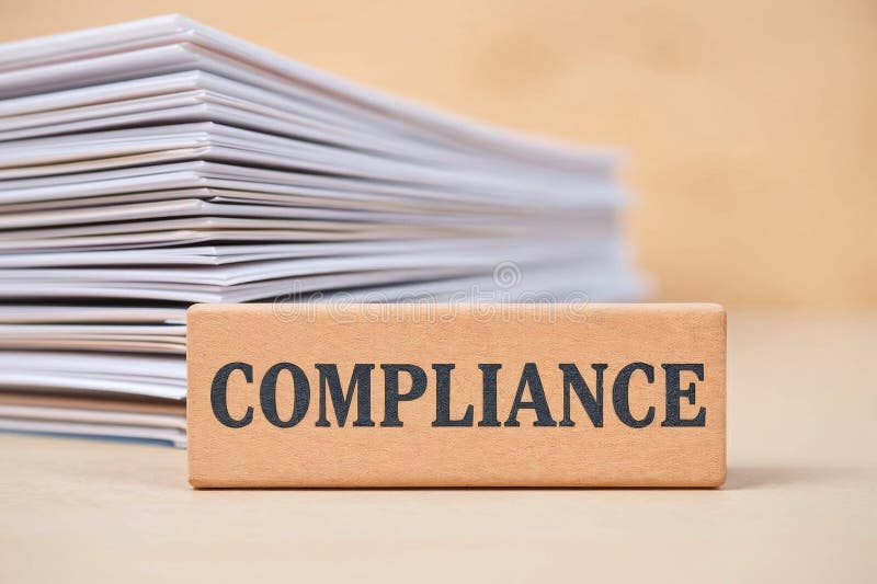 Stack of Documents Behind a COMPLIANCE Block on a Beige Background ...