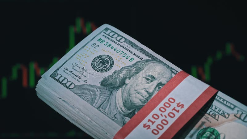 Stack of Dollars in a Hand on the Background of a Stock Market Chart ...