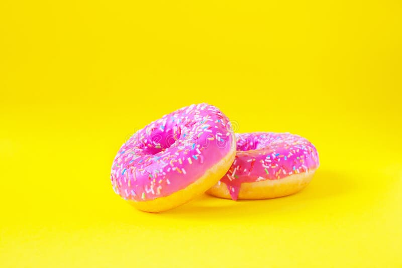A Stack of Donuts with Pink Icing on a Yellow Background Side View ...