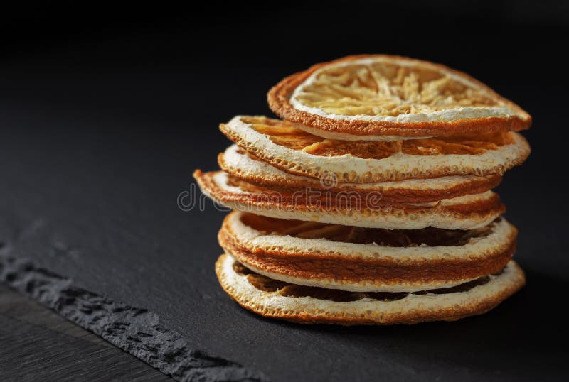 A Stack of Dried Round Orange Slices on a Black Background, with a Copy ... A Stack of Dried Round Orange Slices on a Black Background, with a Copy ...