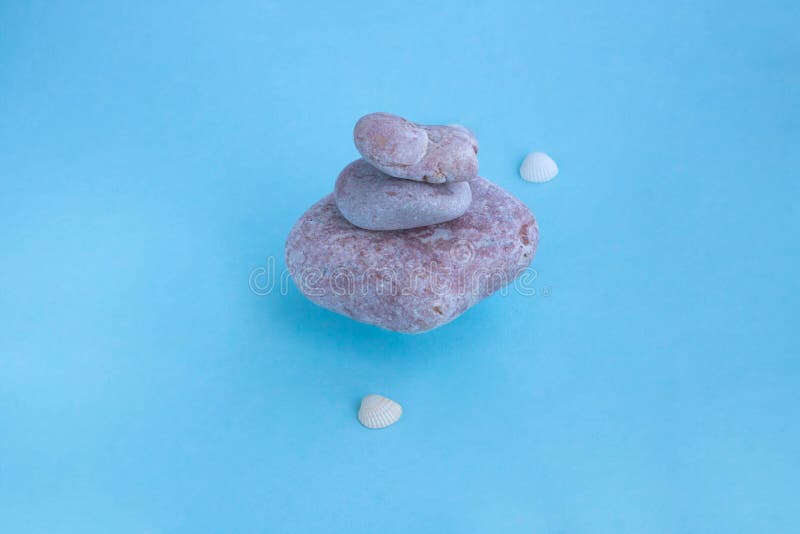 A Stack of Floating Pink Stones and Small Shells on a Blue Background ...